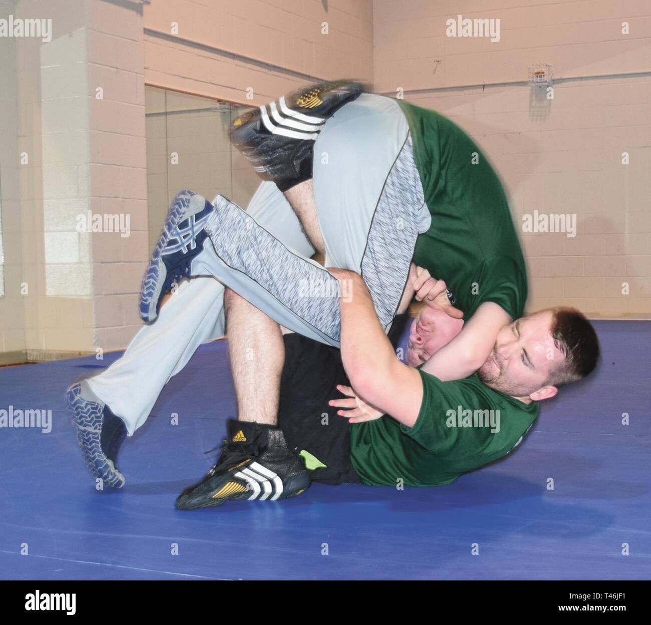 Coach Chris Horne (on his back) shows Nate Pommer a takedown move ...