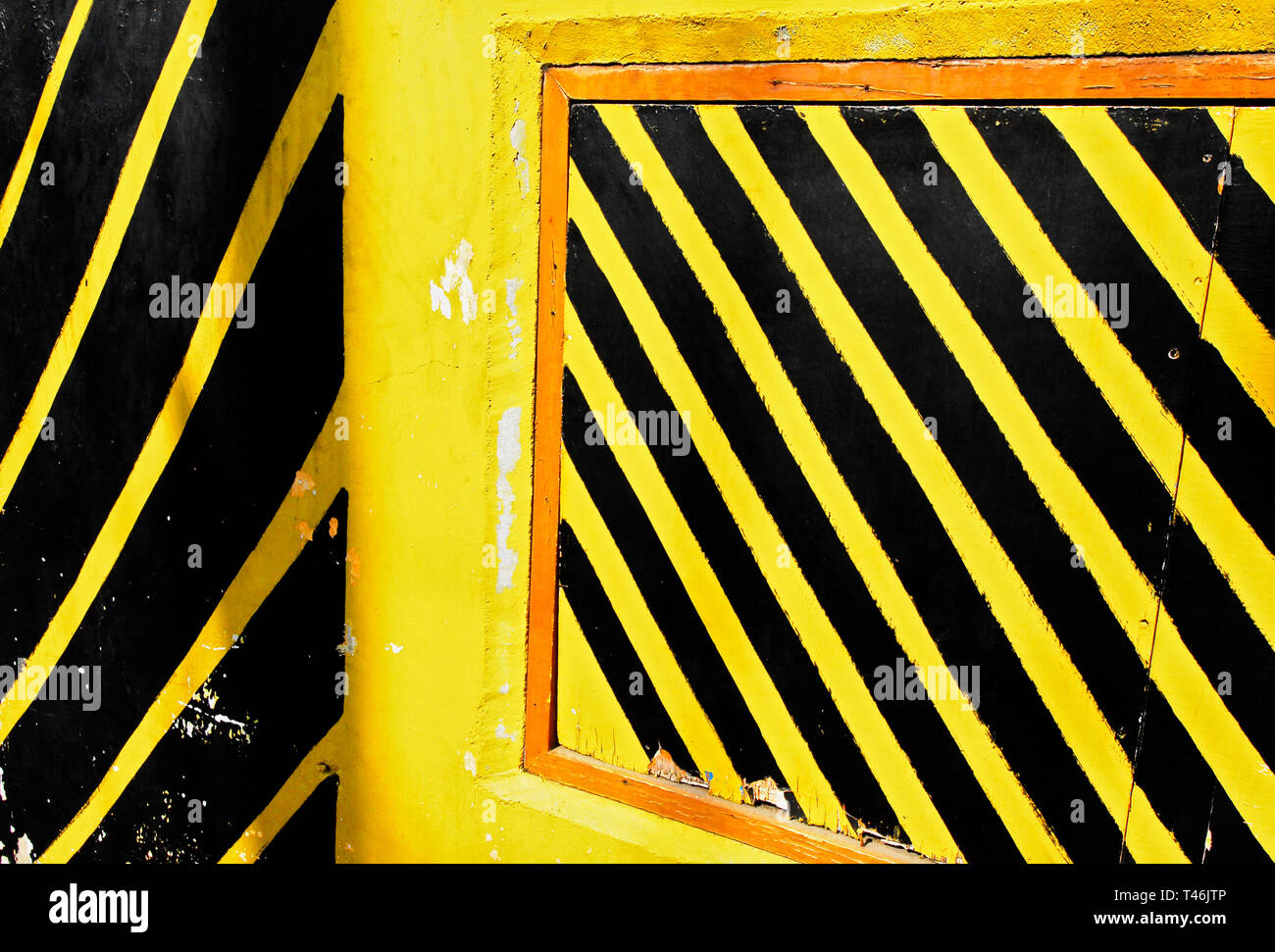 Orange colored window frame filled with a yellow and black striped ...