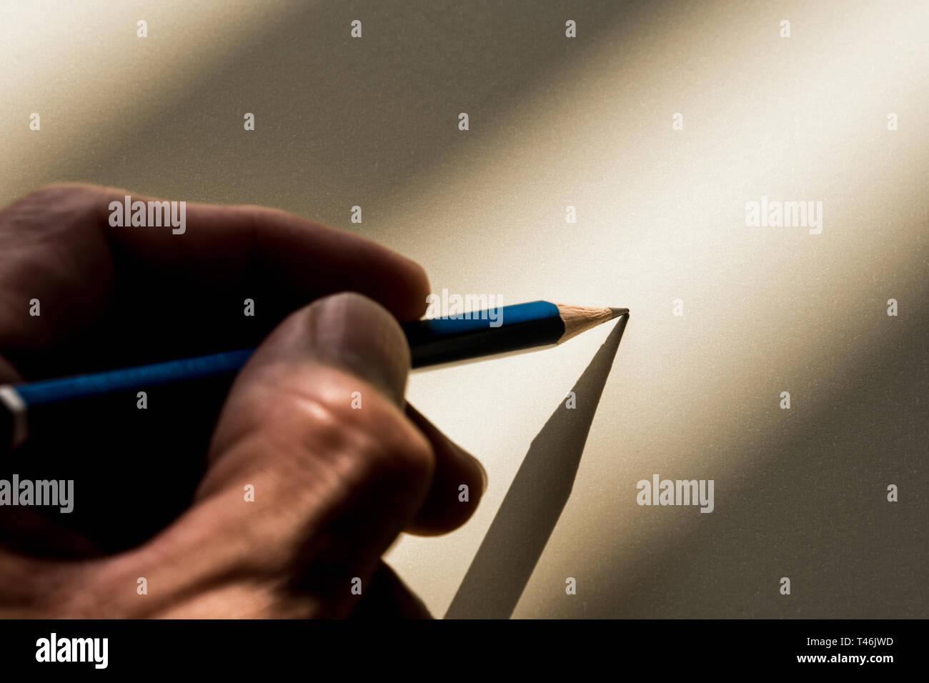 Human's hand holding pencil to write on the paper in shadow Stock Photo ...