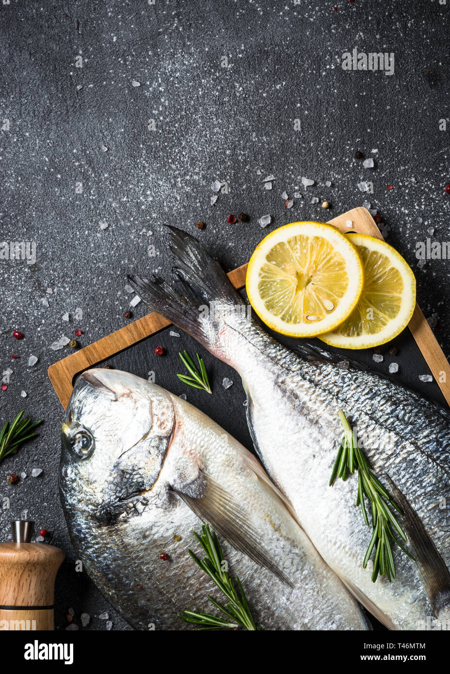 Raw dorado fish on black background Stock Photo - Alamy