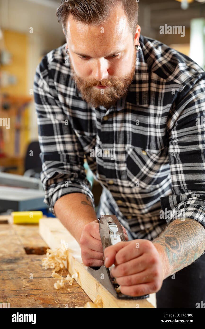 Carpenter work with planer on wood plank in workshop Stock Photo - Alamy