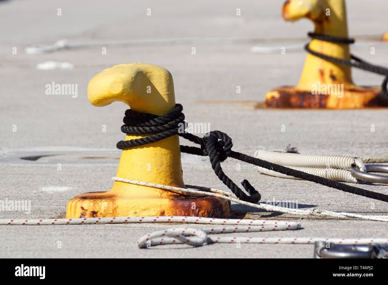 A mooring bollard entwined with a mooring rope. Moored ships at the ...