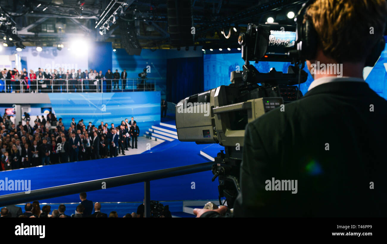A professional cameraman shoots a crowd of people on the studio 4K ...