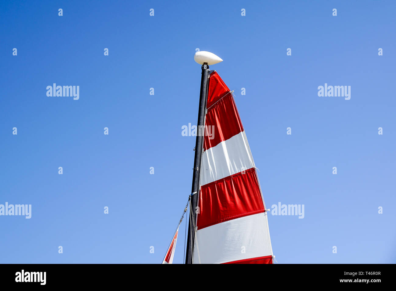 Sailing boat with red sail on a beach Stock Photo - Alamy