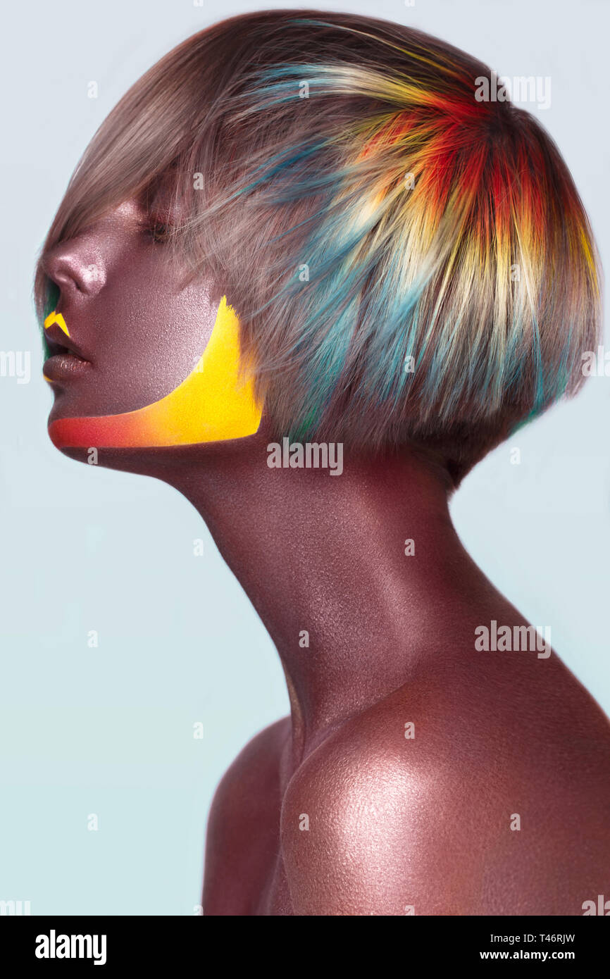 Beautiful girl with multi-colored hair and creative make up and ...