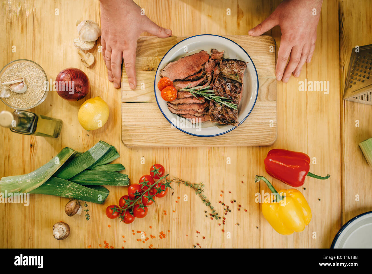 Chef hands and meat slices in a plate, top view Stock Photo - Alamy