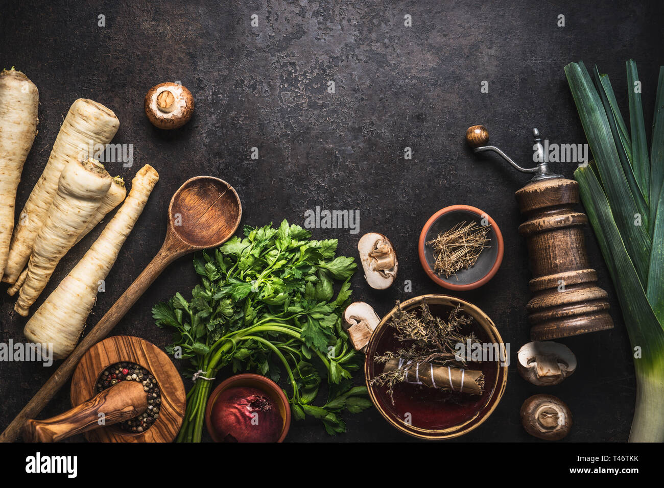 Rustic food background with parsley root vegetables, herbs,spices ,leek ...