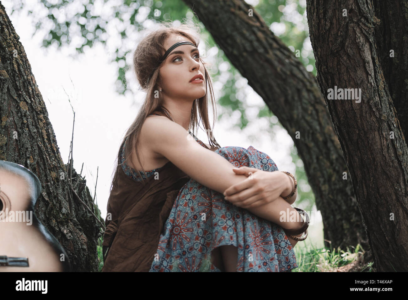 beautiful hippie girl sitting near big trees in the forest Stock Photo - Alamy