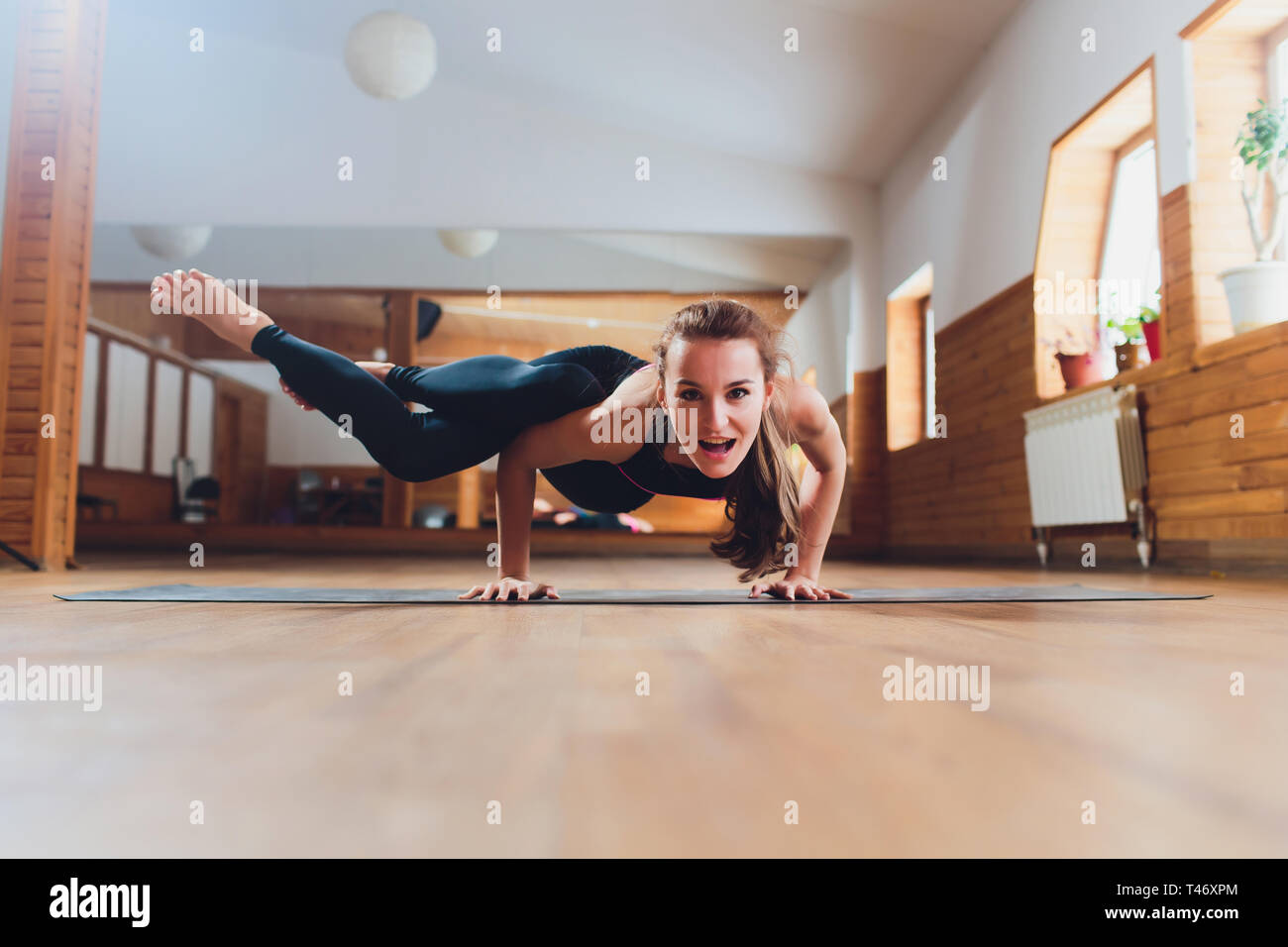 Young attractive yogi woman practicing yoga, standing in Parsva ...