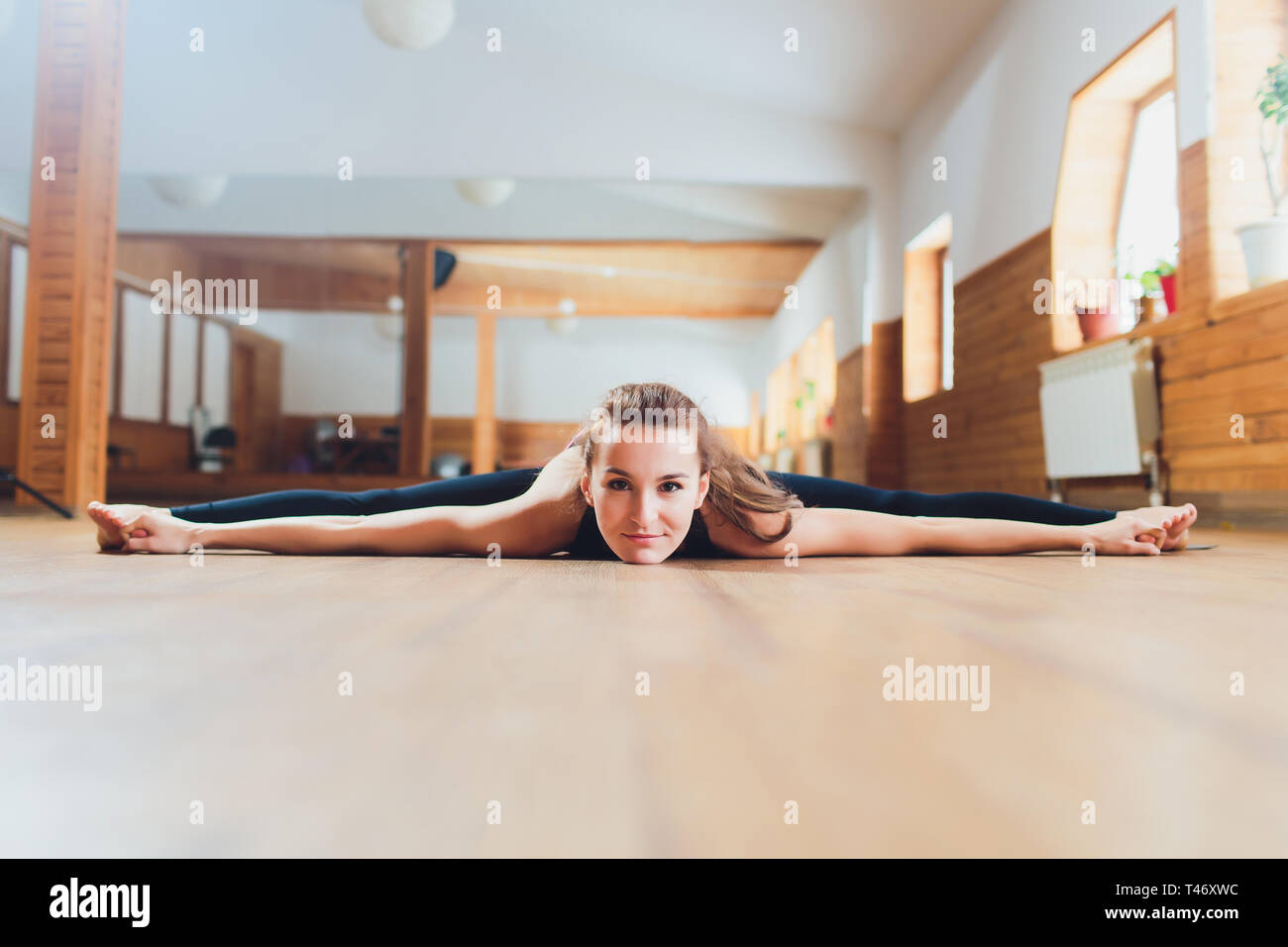 full-length portrait of beautiful woman doing the youga splits ...