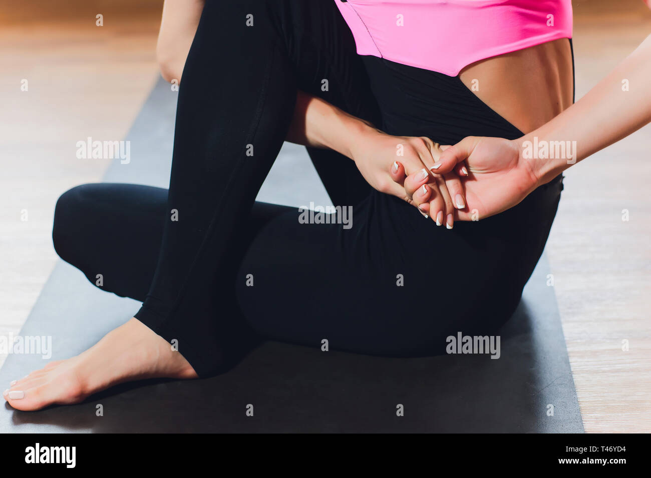 Close-up of a girl doing an asana bending forward with her hands ...
