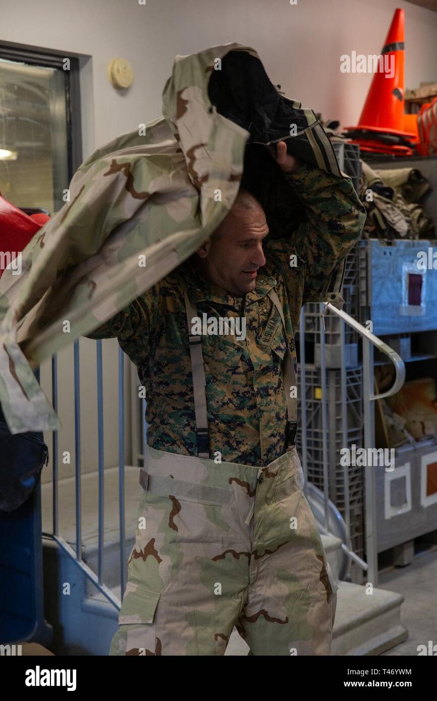 U.S. Marine Col. Frank Latt dons a mission oriented protective posture ...