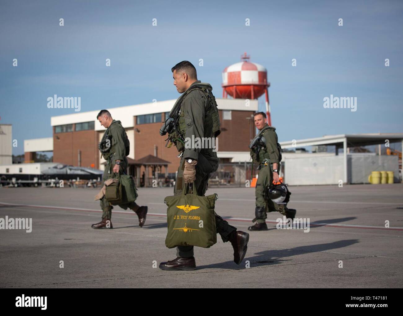 U.S. Marine Corps Lt. Col. Julian Flores, center, walks on the flight ...