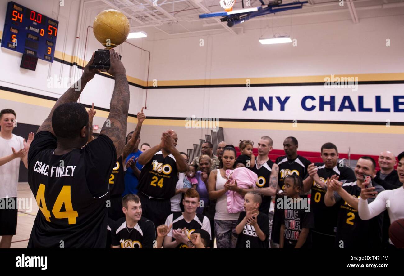 The coach of team U.S. Army Central Command (ARCENT) holds up a trophy ...