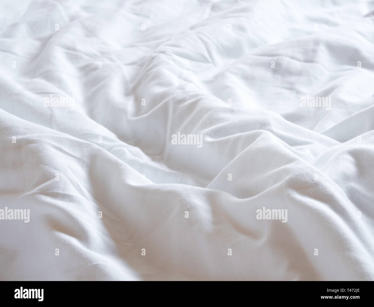 White blanket crumpled on the bed Stock Photo - Alamy