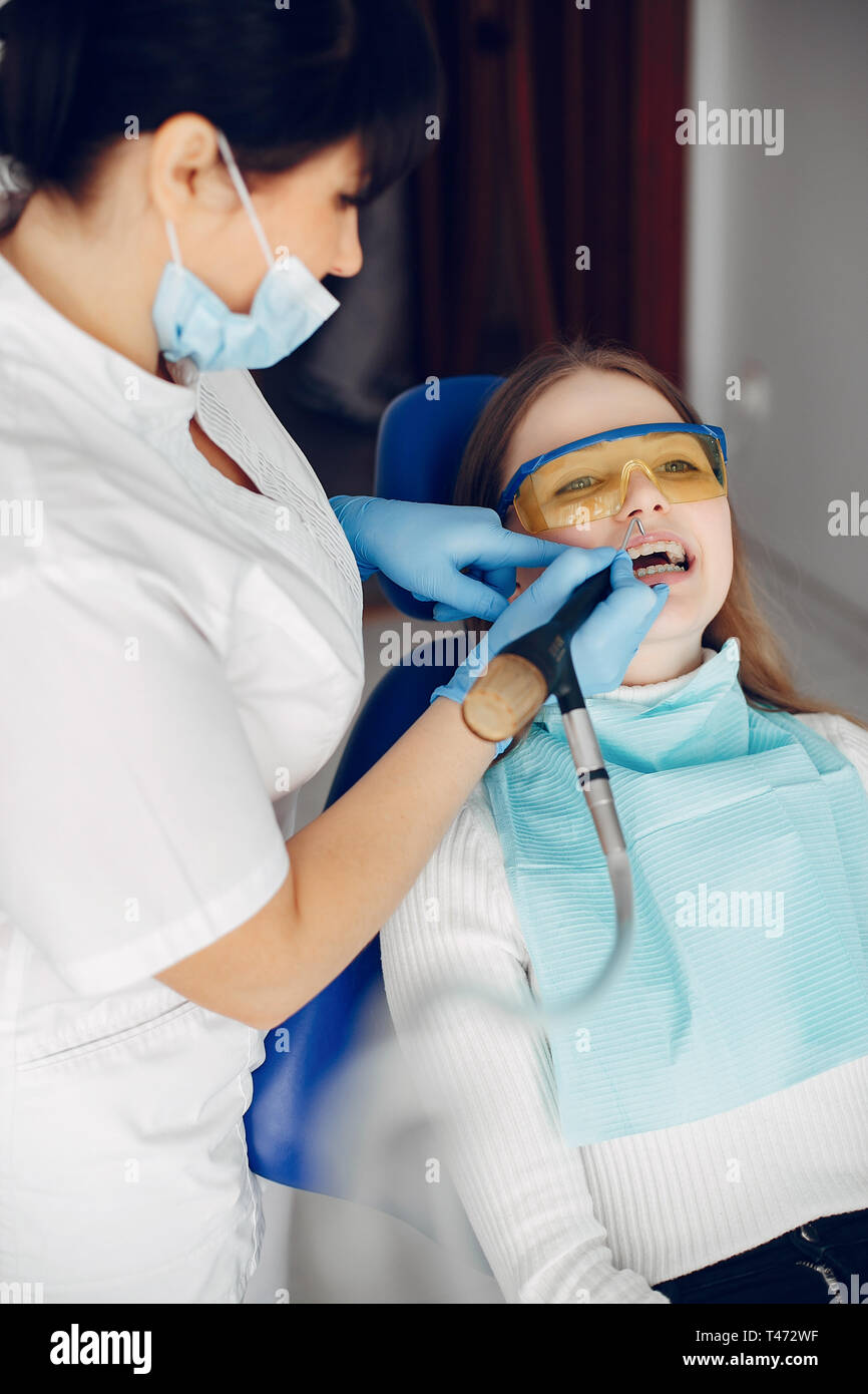 Beautiful girl sitting in the dentist's office Stock Photo - Alamy