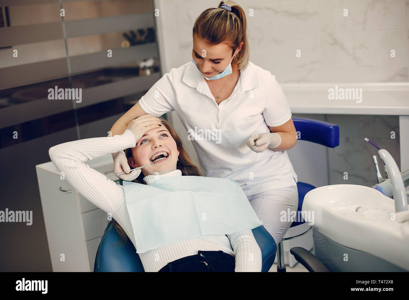 Beautiful girl sitting in the dentist's office Stock Photo - Alamy
