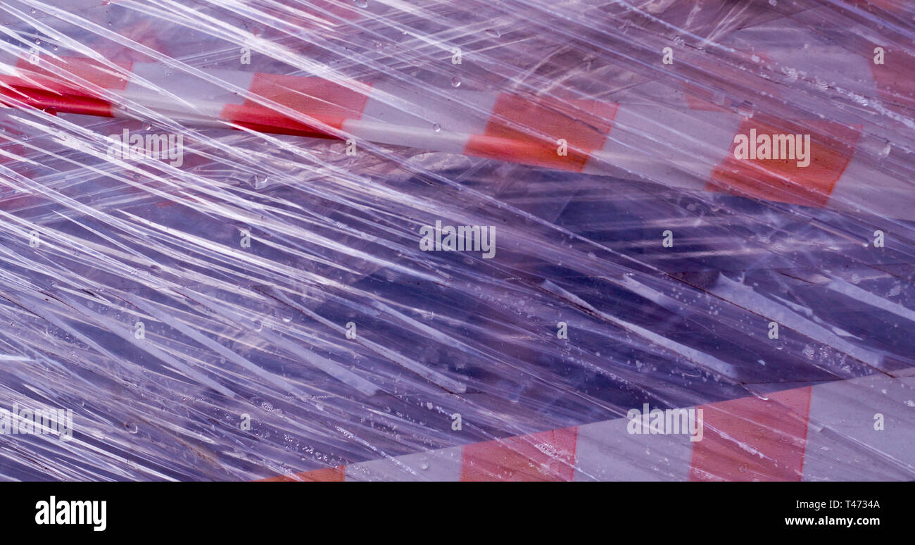 warning construction tape covered in plastic. background, industrial ...