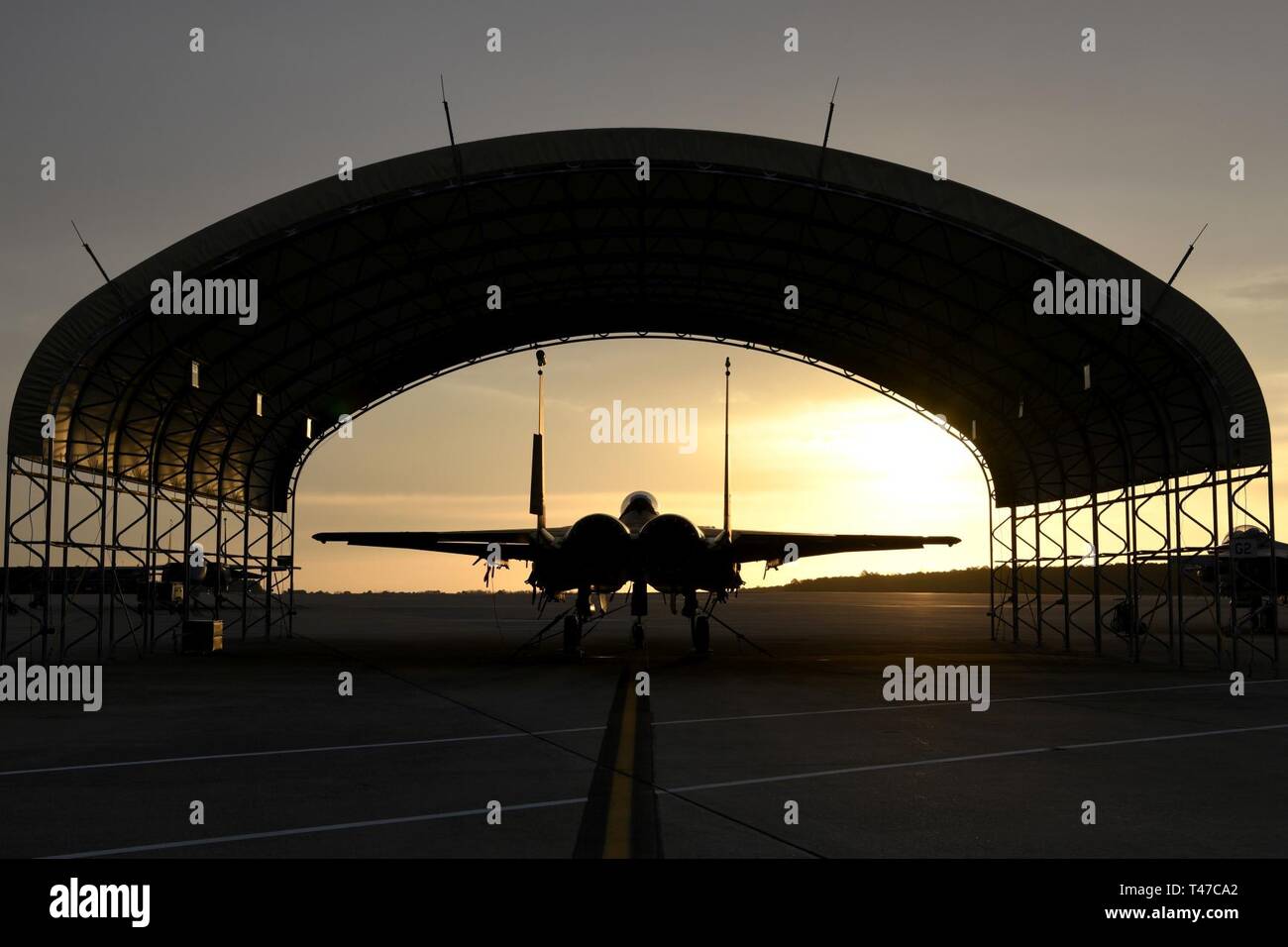 A U.S. Air Force F-15E Strike Eagle sits under a canopy on the ...