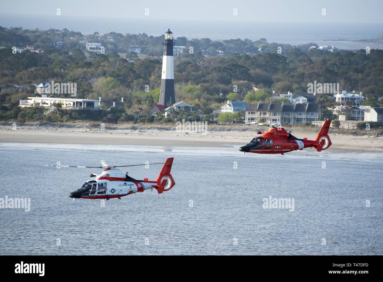 Two Coast Guard Air Station Savannah MH-65 Dolphin helicopters fly in ...