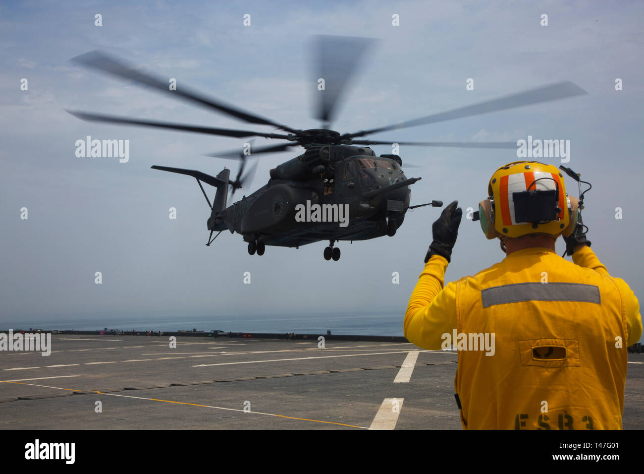 190411-A-YD127-1032 ARABIAN GULF (April 11, 2019) U.S. Sailor directs a helicopter on to the ...