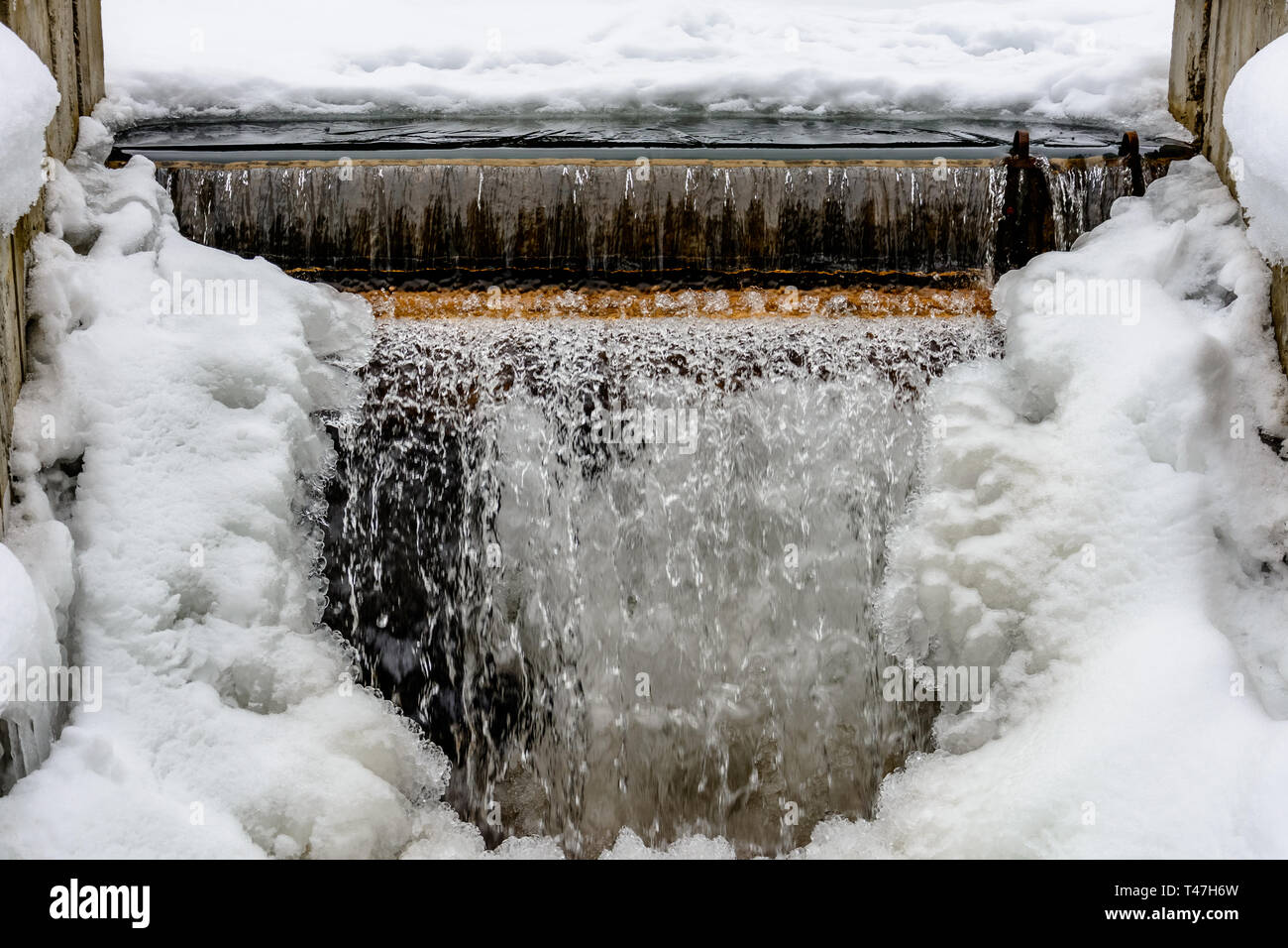 A small frozen waterfall, cold water, snow and ice, winter and frost ...
