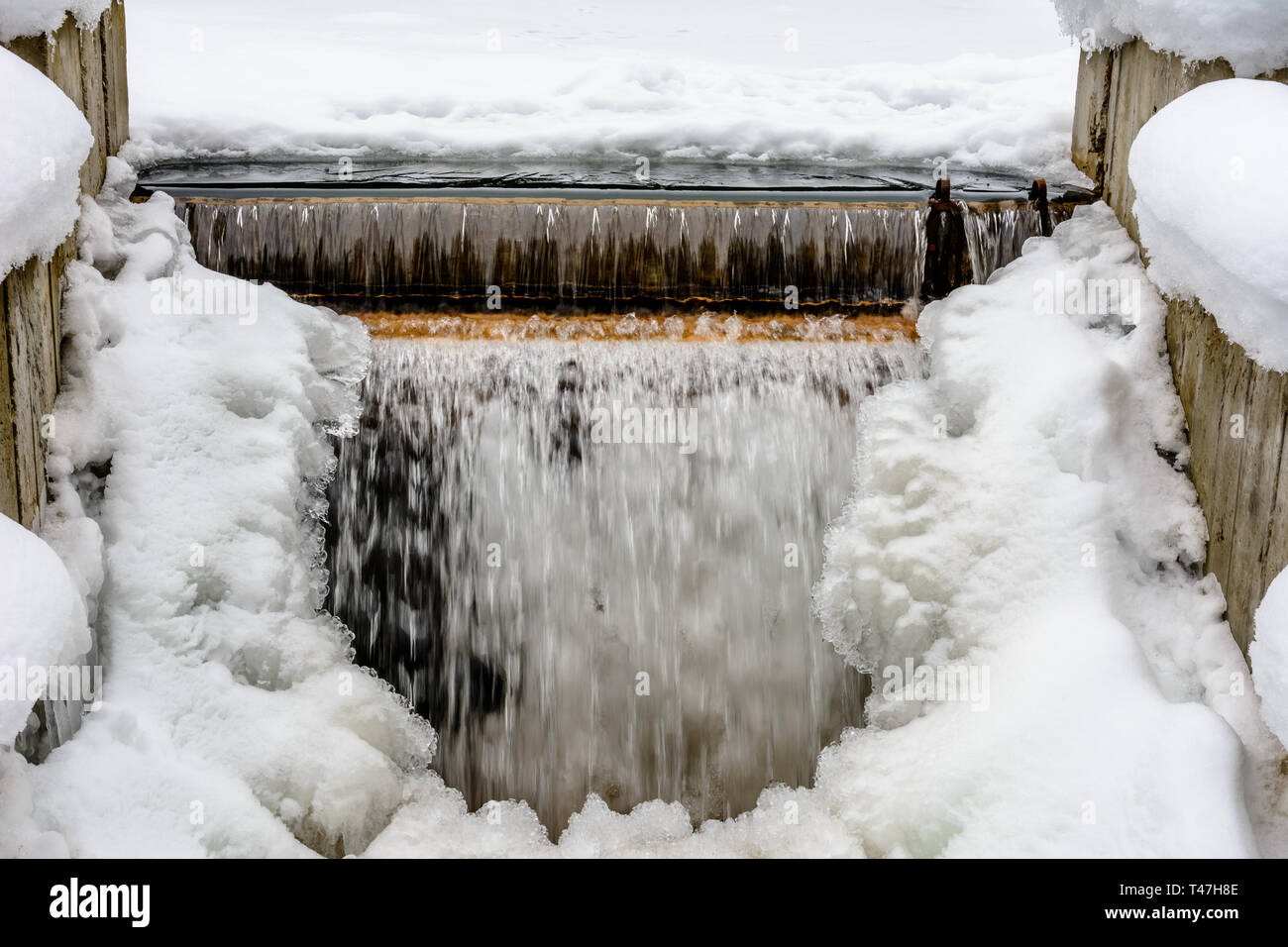 A small frozen waterfall, cold water, snow and ice, winter and frost ...