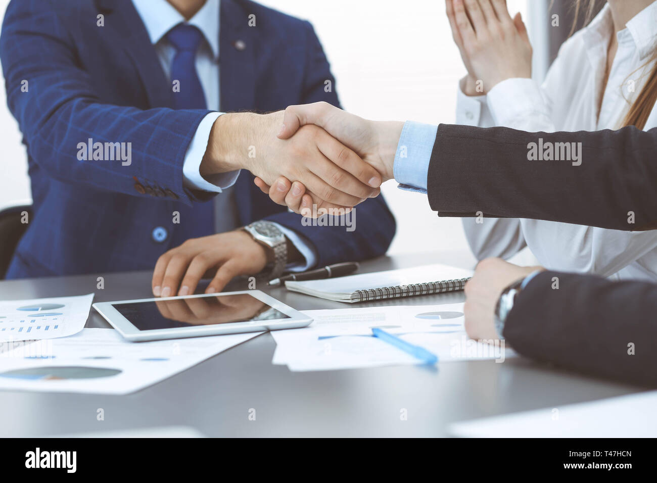 Business people shaking hands, finishing up a papers signing. Meeting ...