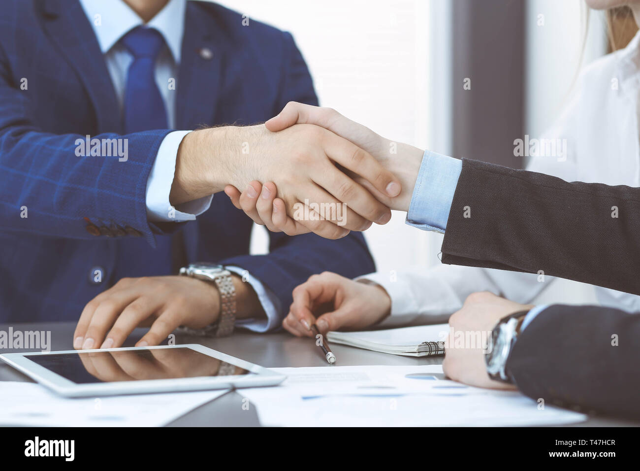 Business people shaking hands, finishing up a papers signing. Meeting ...
