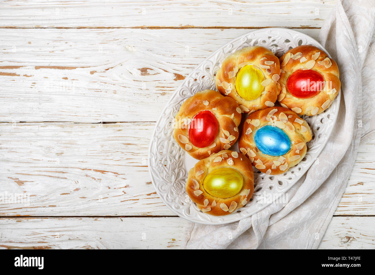 Traditional Easter buns decorated with eggs, almond petals and lemon ...