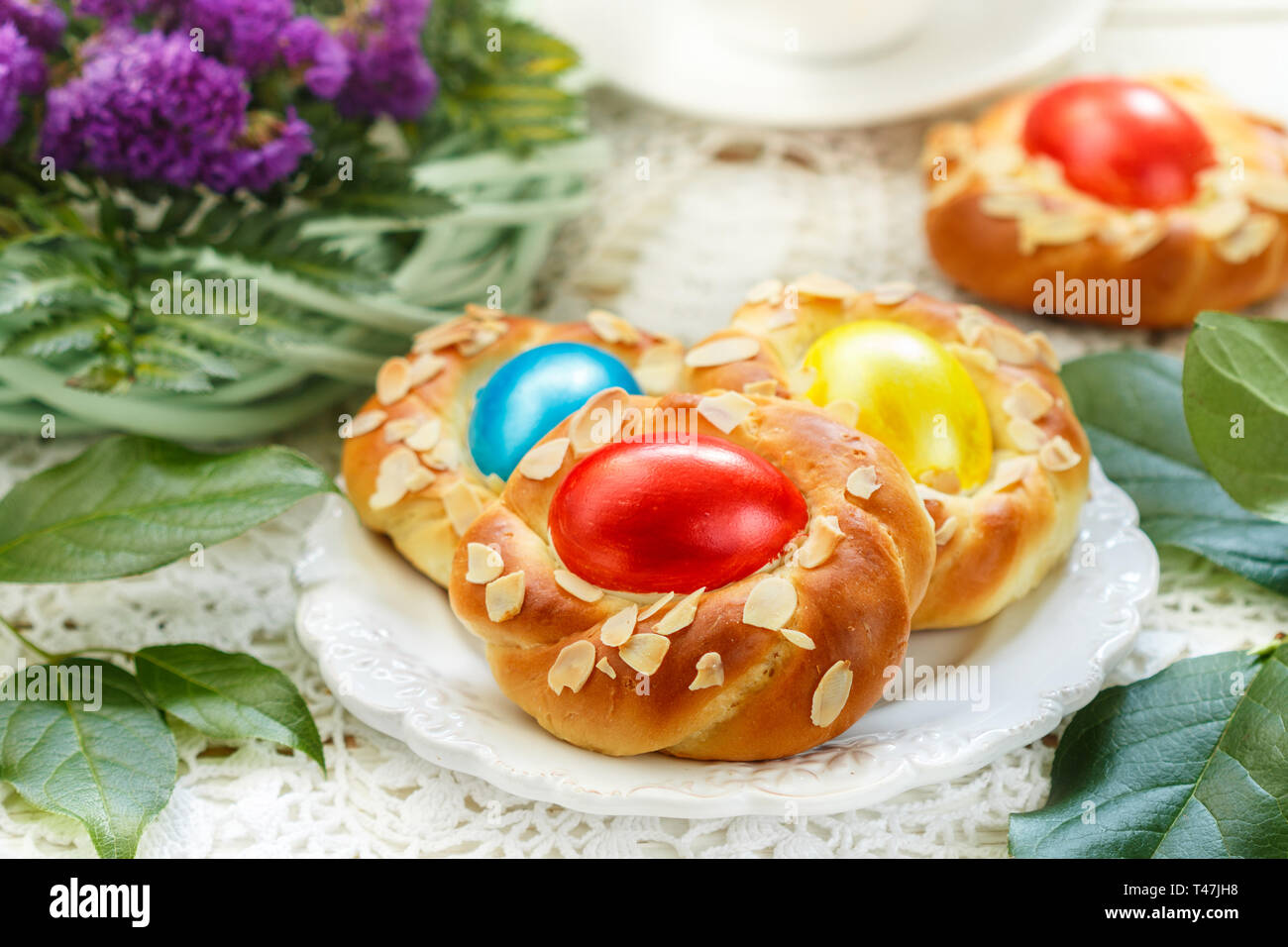 Traditional Easter buns decorated with eggs, almond petals and lemon ...