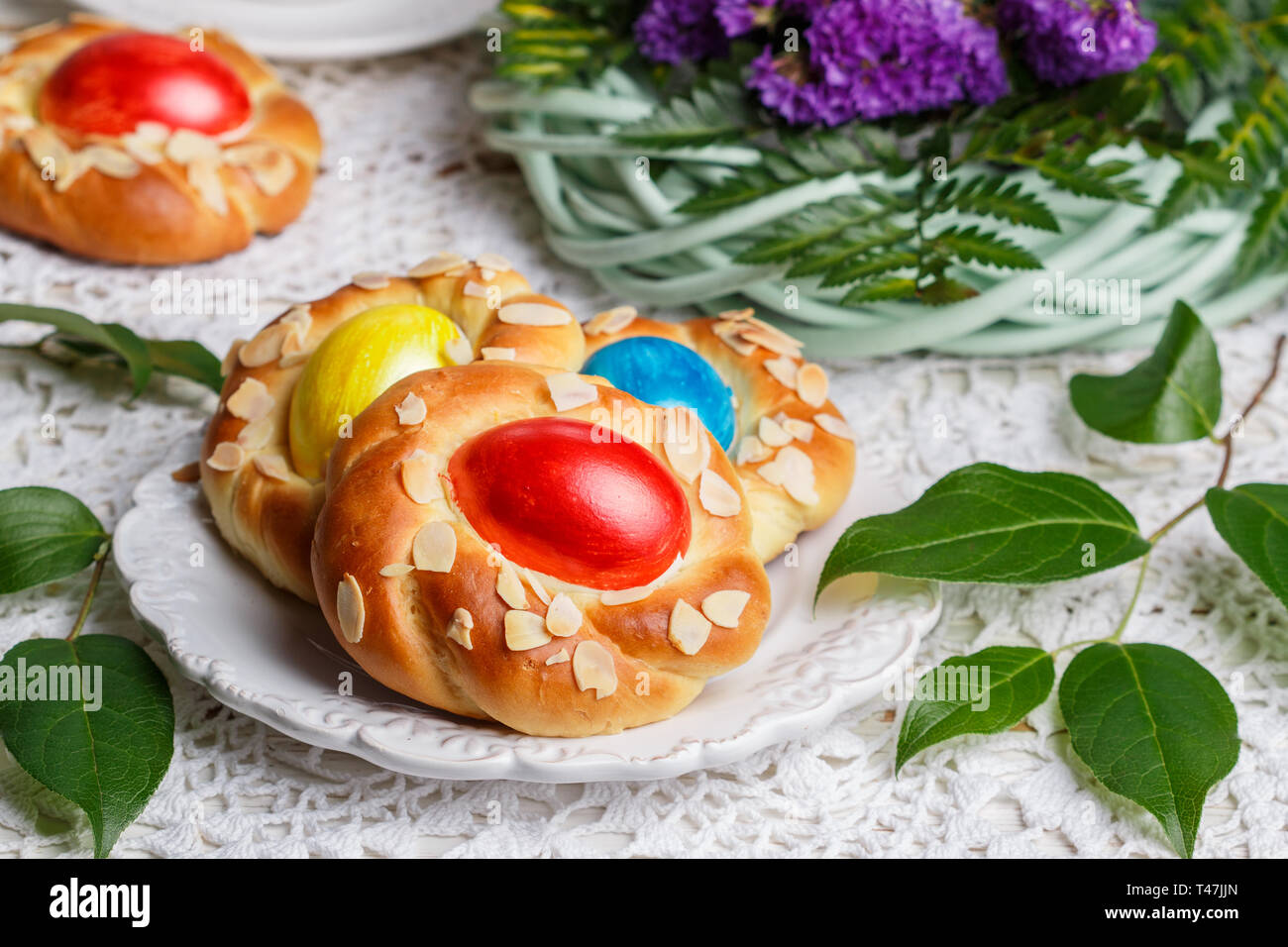Traditional Easter buns decorated with eggs, almond petals and lemon ...
