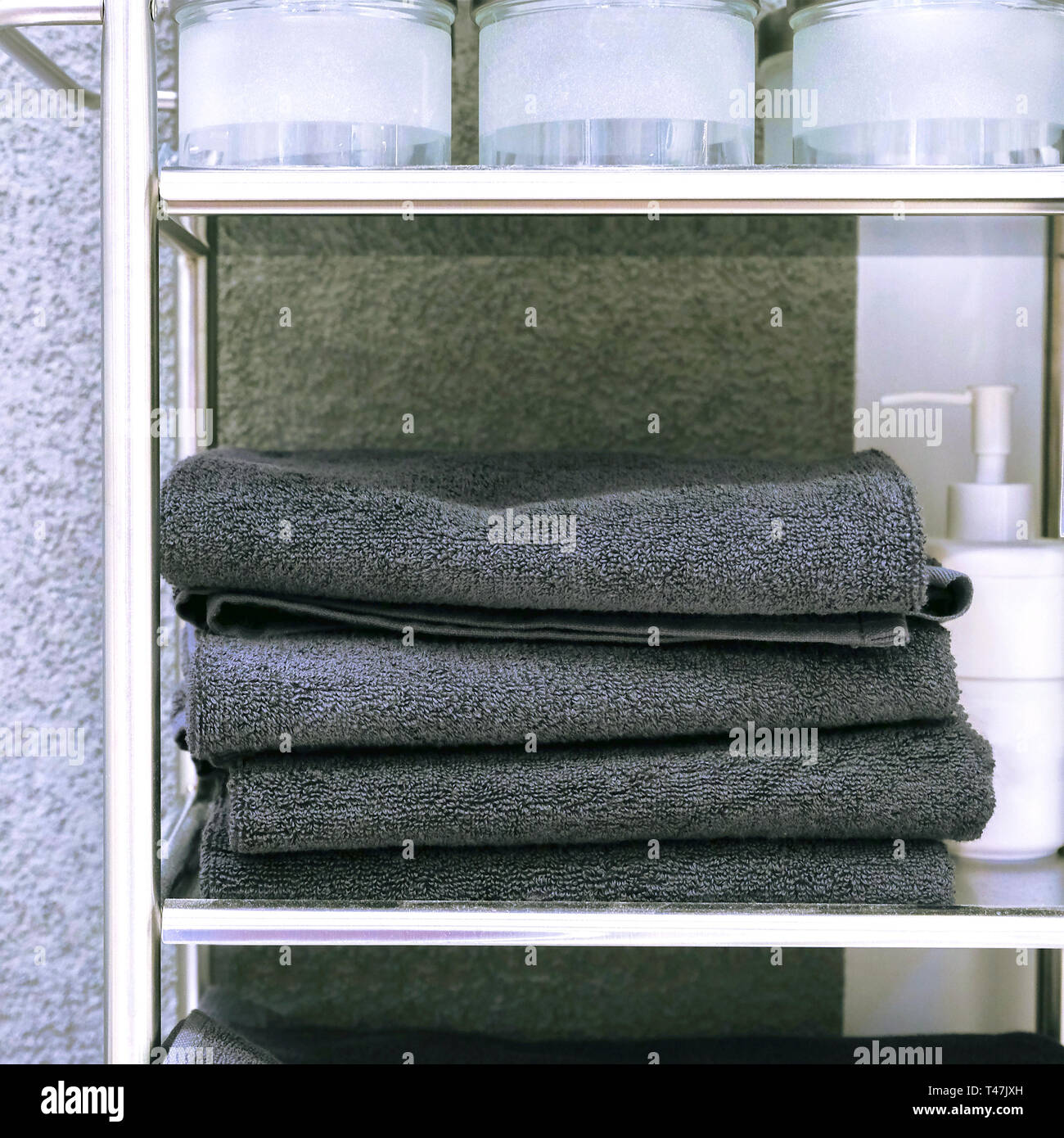 Clean colored towels hanging on the hanger in the bathroom. Towels are ...