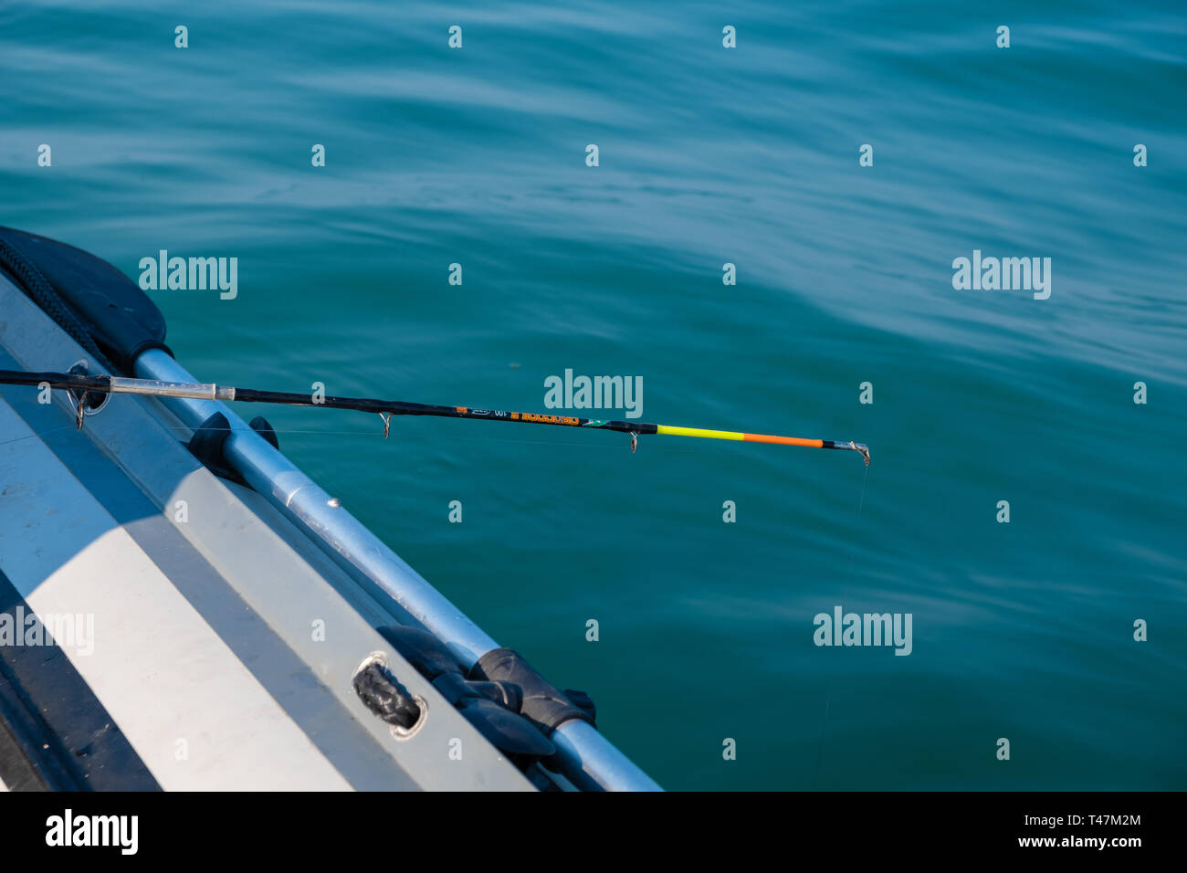 Fish-rod in fishermen's hand. Fishing at inflatable boat Stock Photo ...