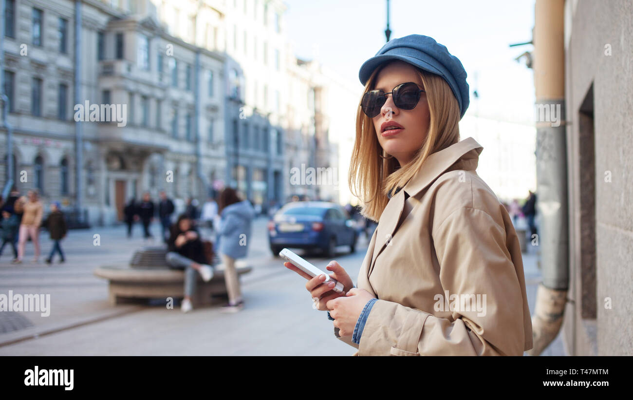 Cute fashionable girl uses smartphone to navigate the city, watch the ...
