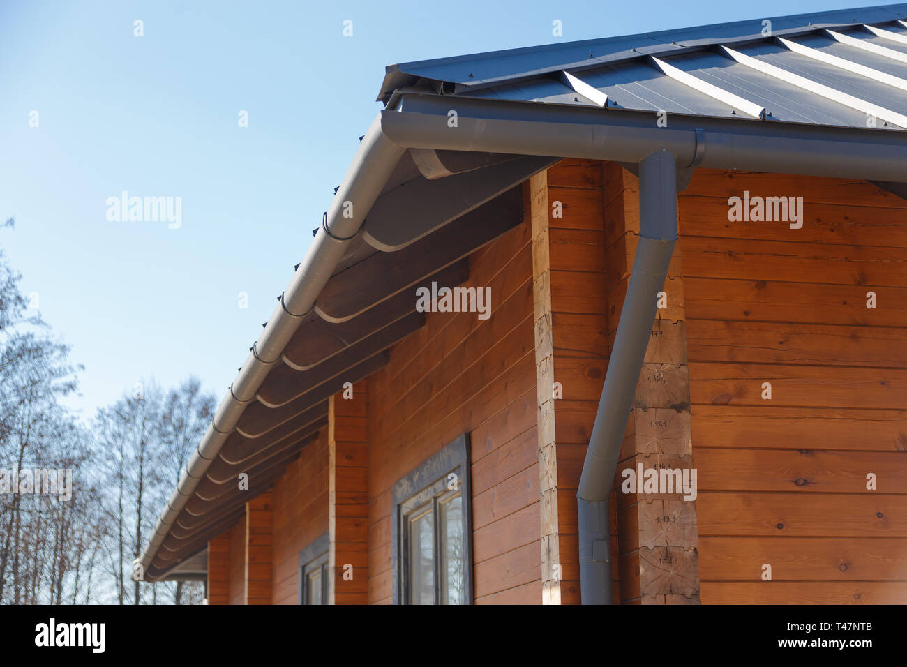 Wood log house with roof drainage system Stock Photo - Alamy