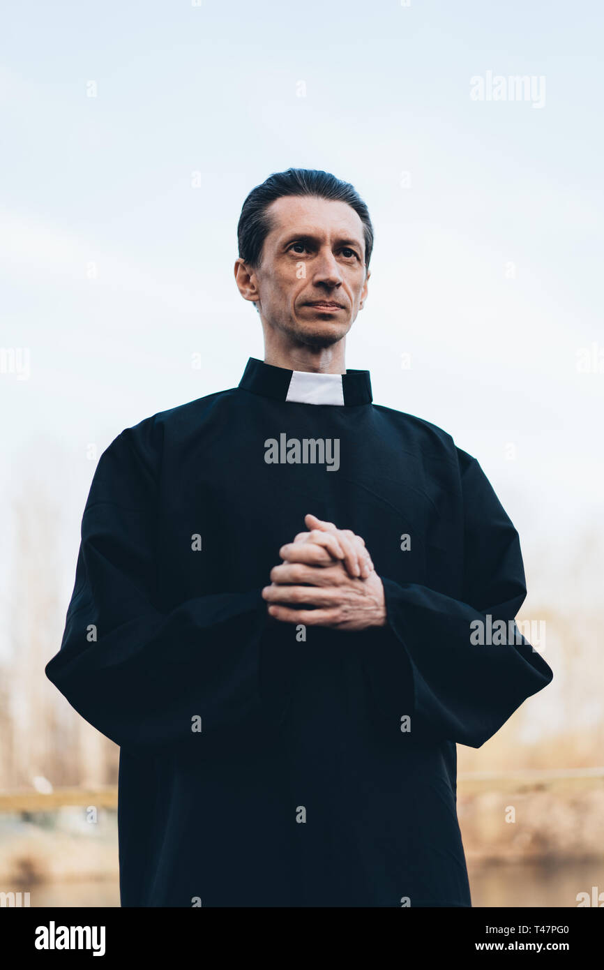 Portrait of handsome catholic priest or pastor with collar Standing ...