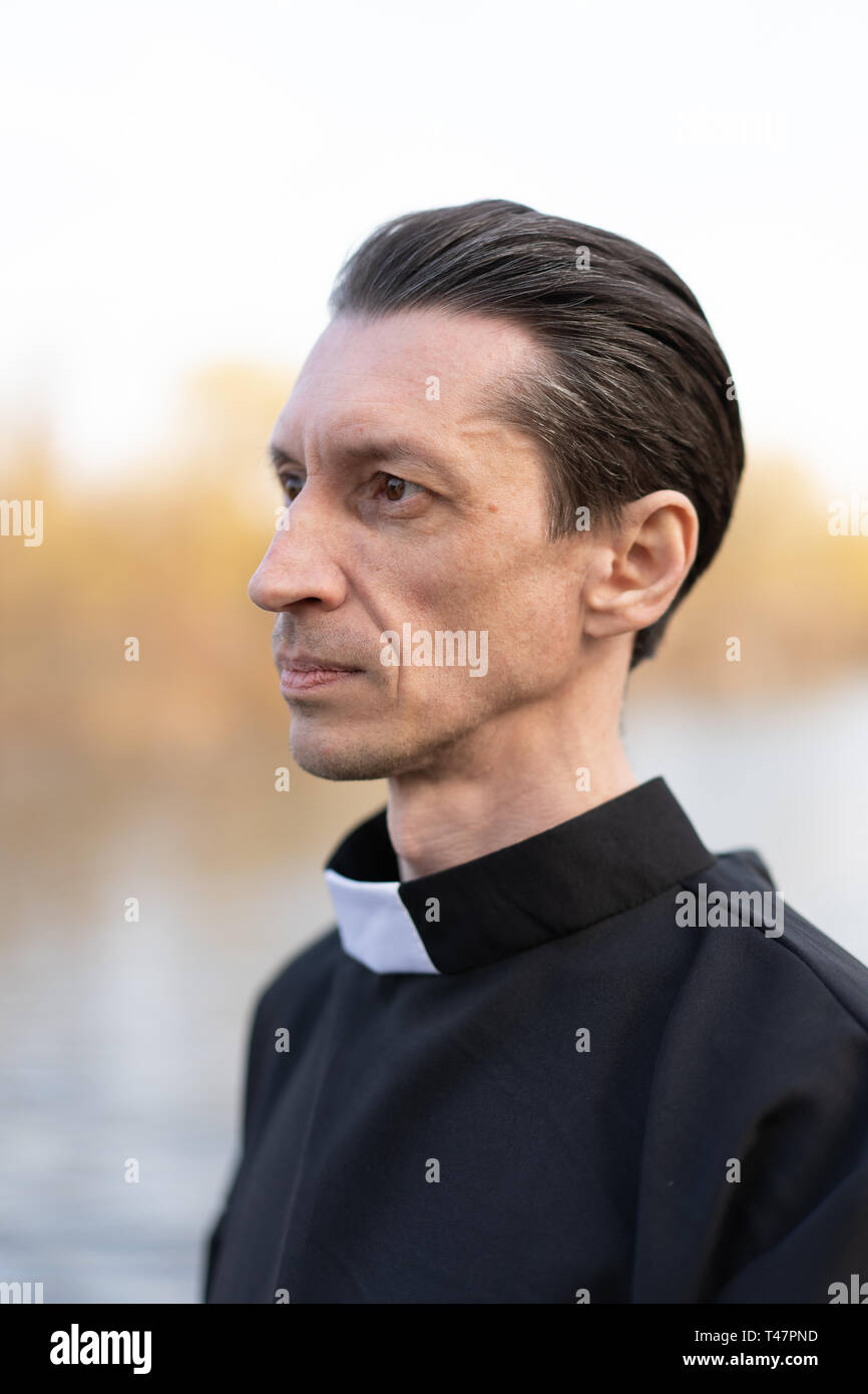 Portrait of handsome catholic priest or pastor with collar Standing ...