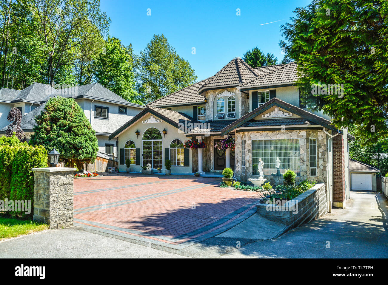 Luxury residential house with garage on back yard and tile paved front ...