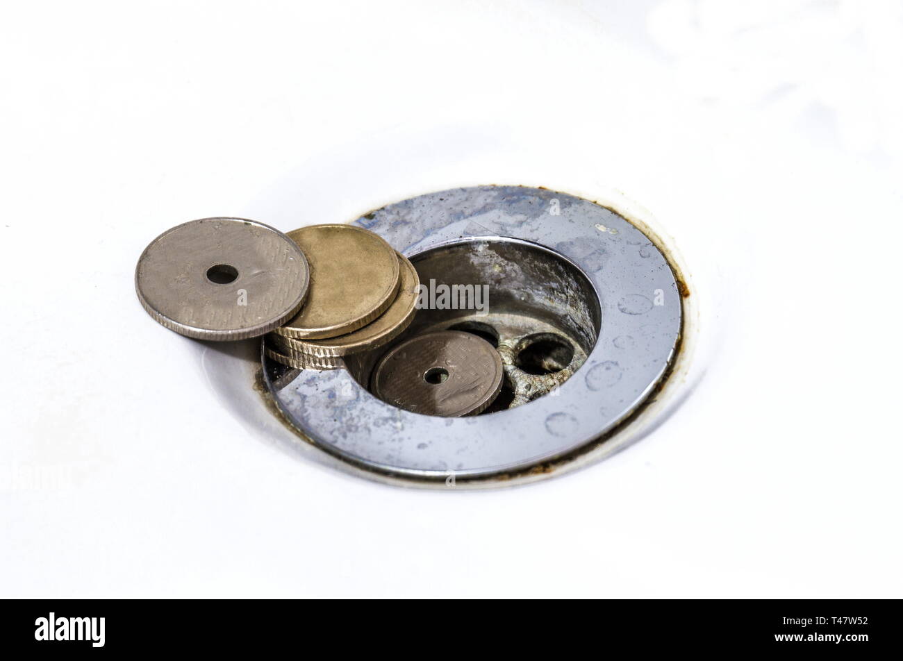 Coins falling down a dirty drain image with copy space in landscape ...