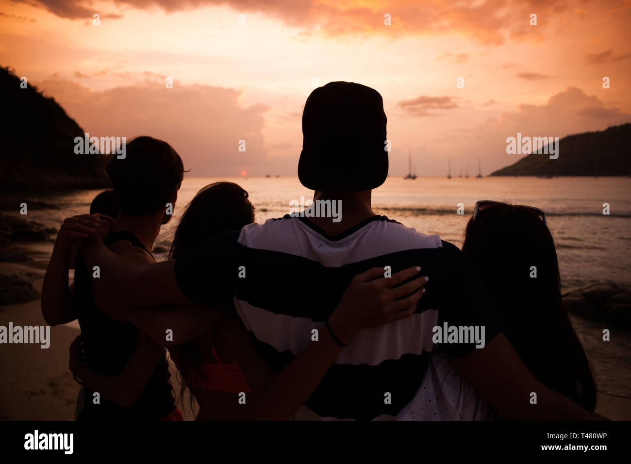 Group of happy people at sea beach at sunset Stock Photo - Alamy
