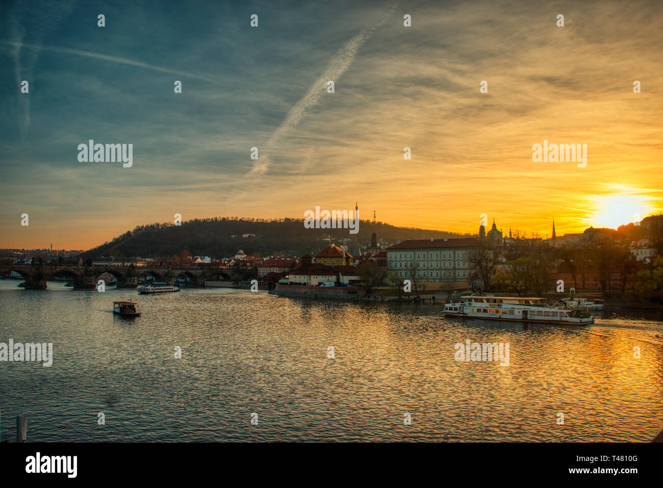 Prague sunset by Vltava river with boats warm light Stock Photo - Alamy