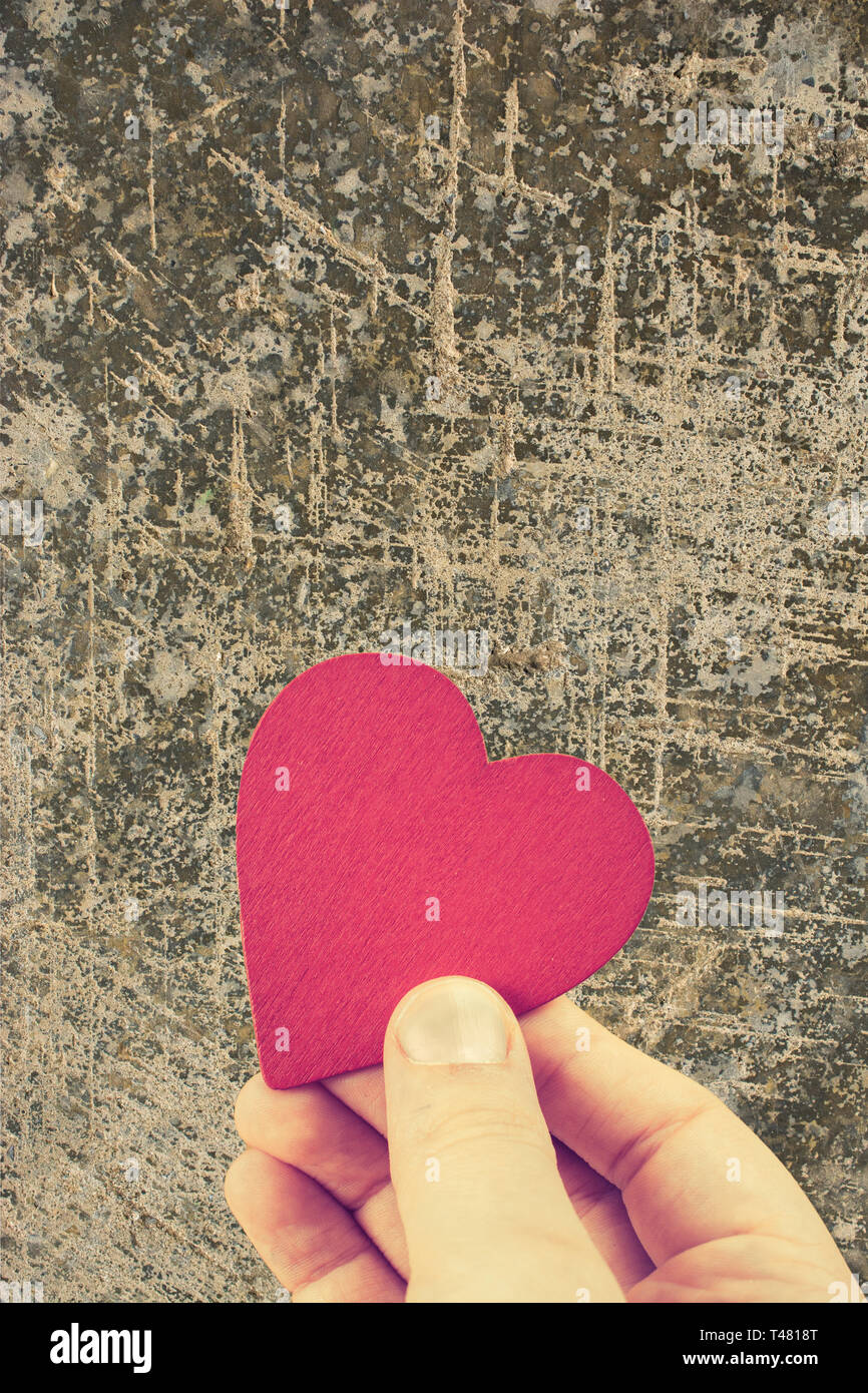 Red heart shaped object in hand as love concept Stock Photo - Alamy