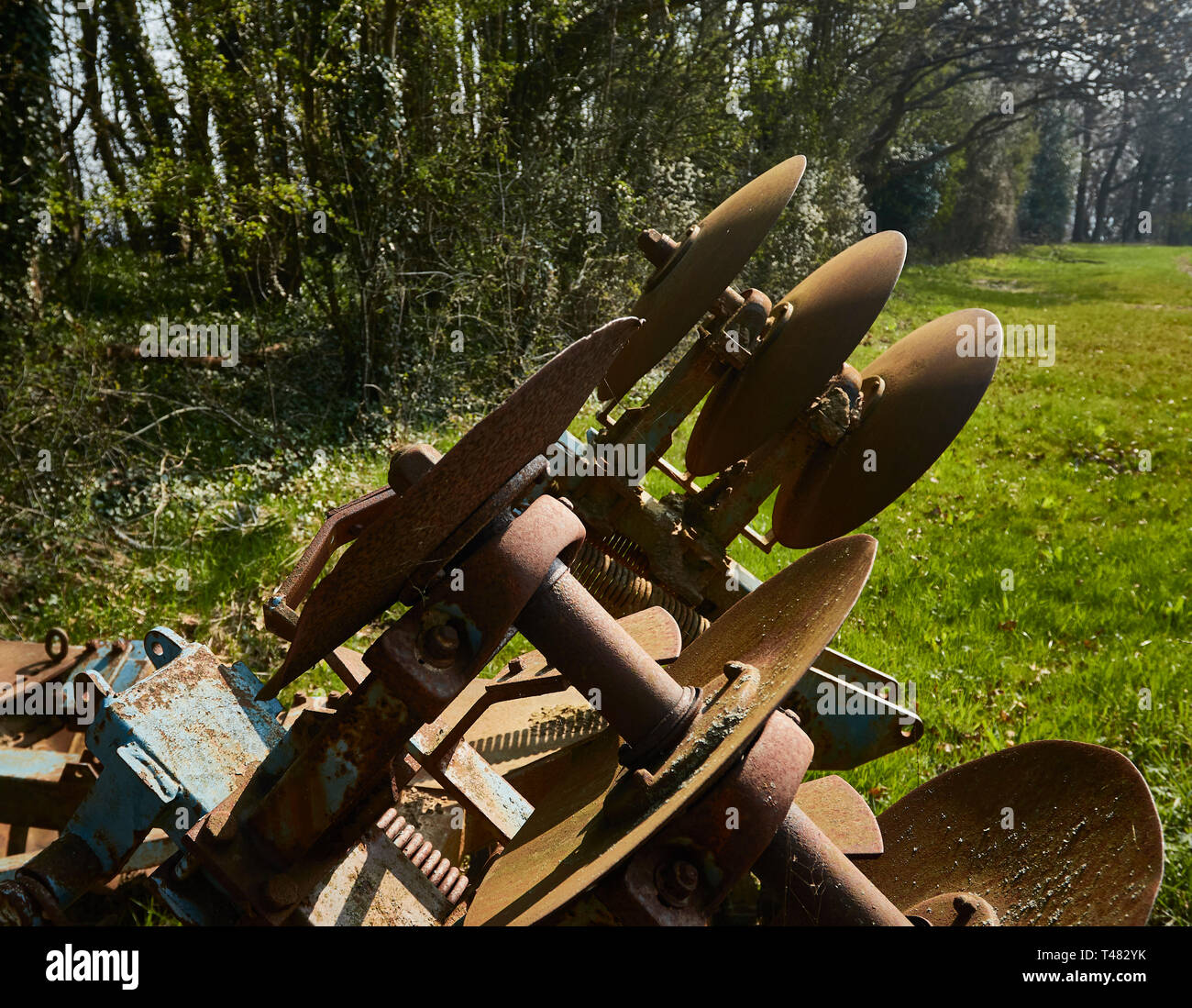Farm machinery in foreground of green Kent farmland in spring, England ...