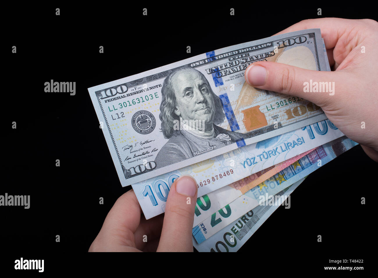 Hand holding American dollar banknotes isolated on black background ...