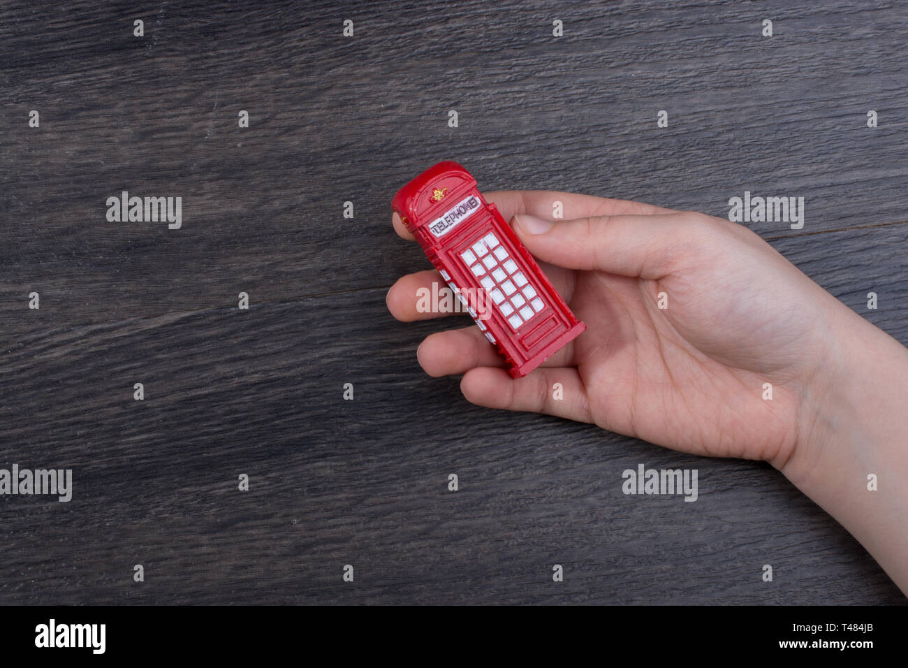 Hand holding a phone booth on a dark background Stock Photo - Alamy