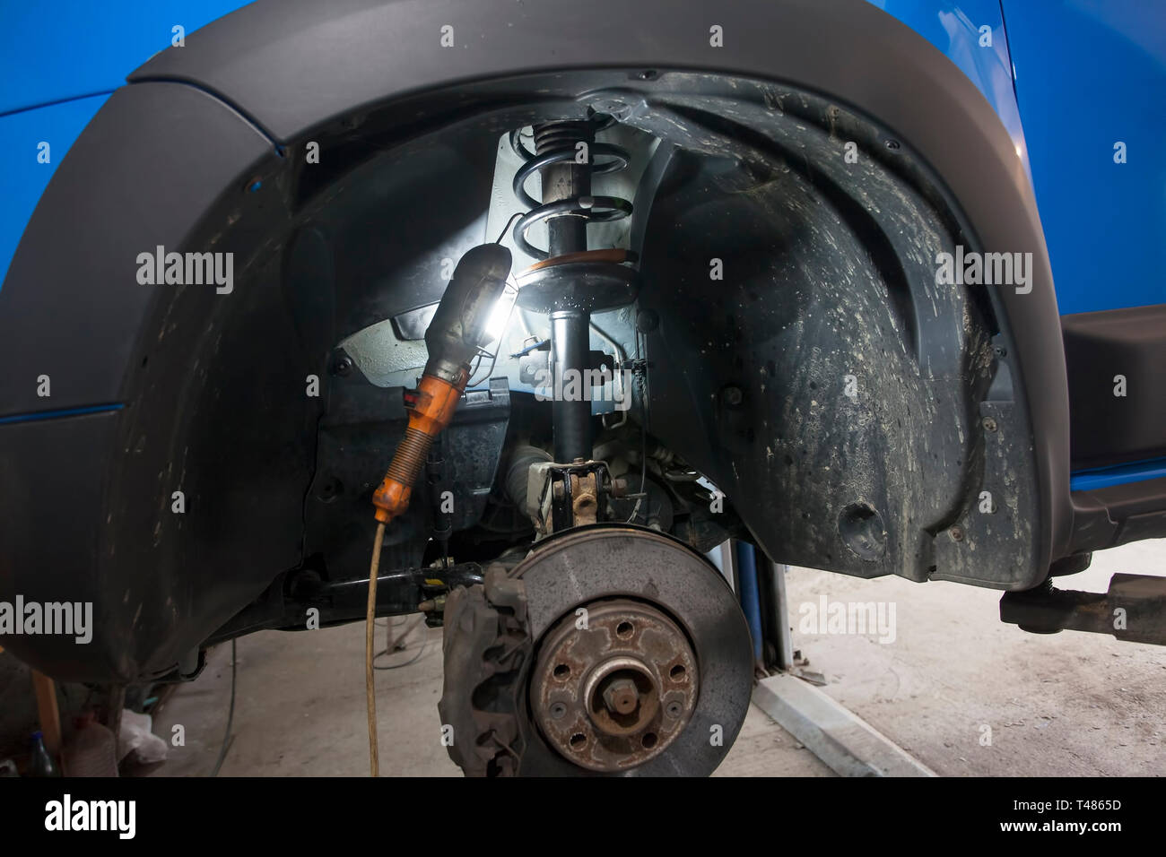 car in service. mechanical work on shock absorber, suspension component ...