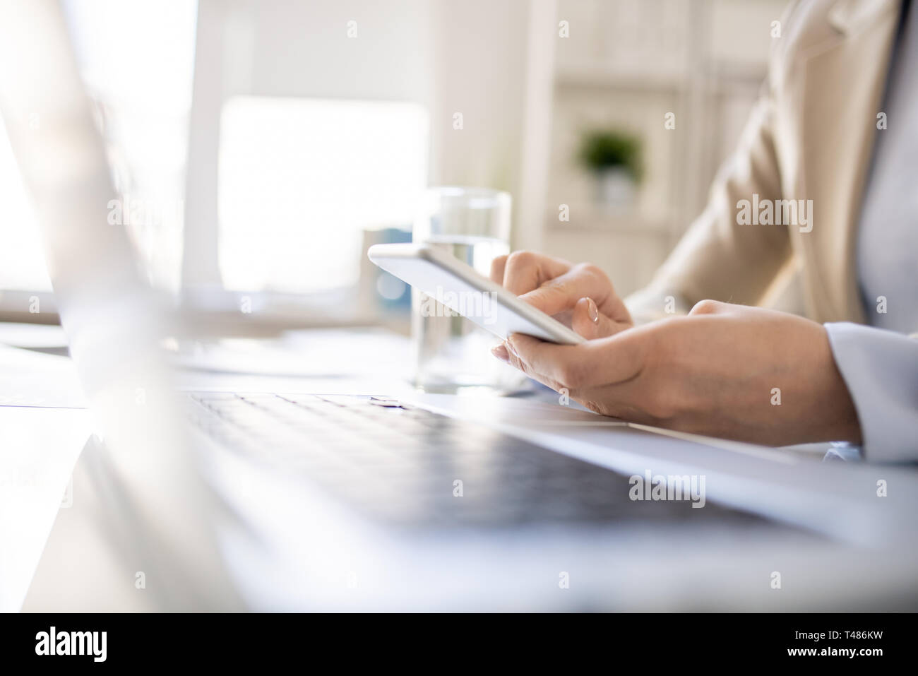Using smartphone while working in office Stock Photo - Alamy