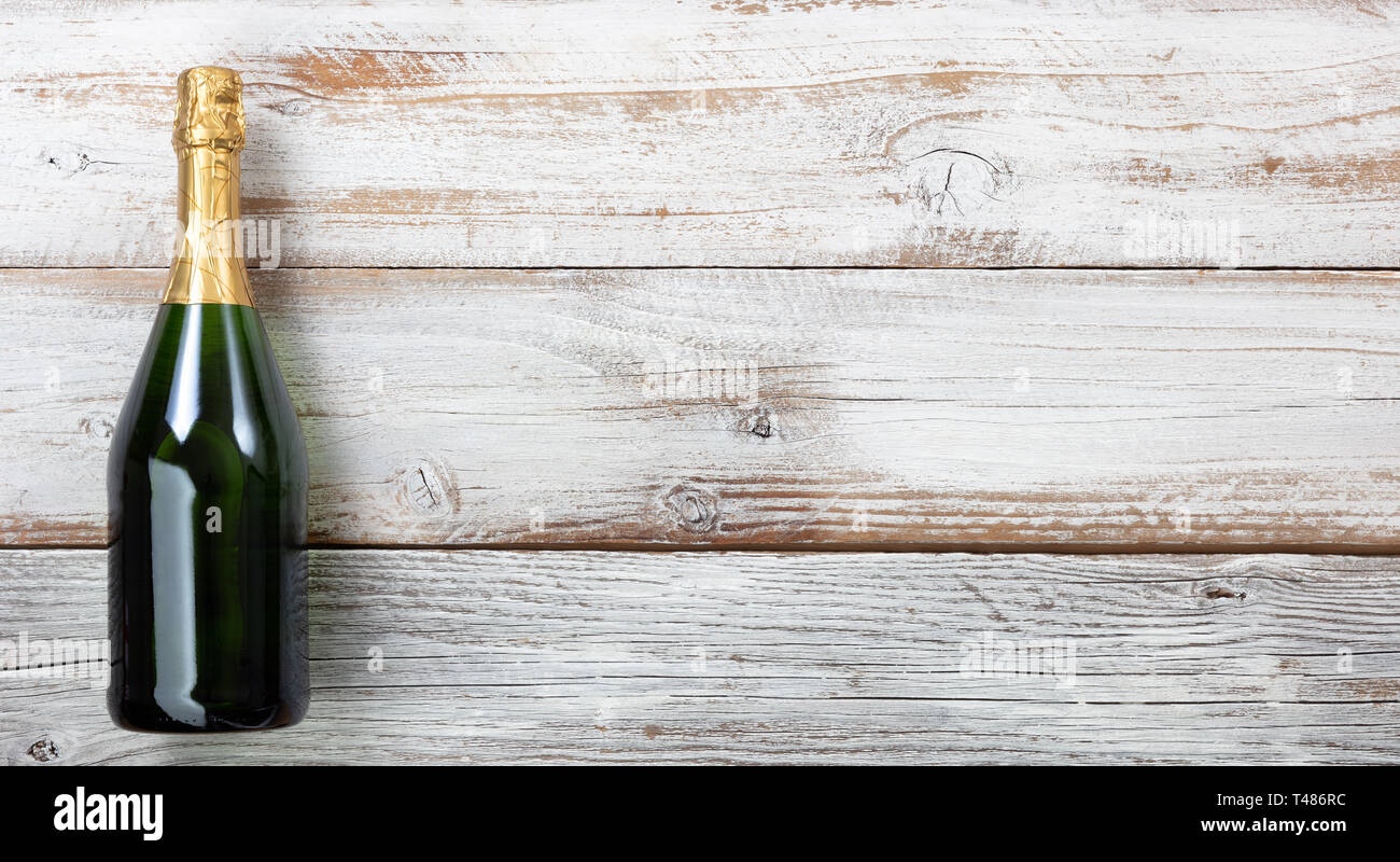Anniversary background with a bottle of champagne on white rustic wood ...