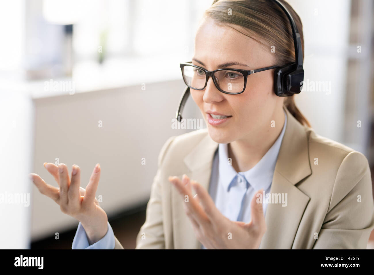 Manager in headset explaining information to client Stock Photo - Alamy
